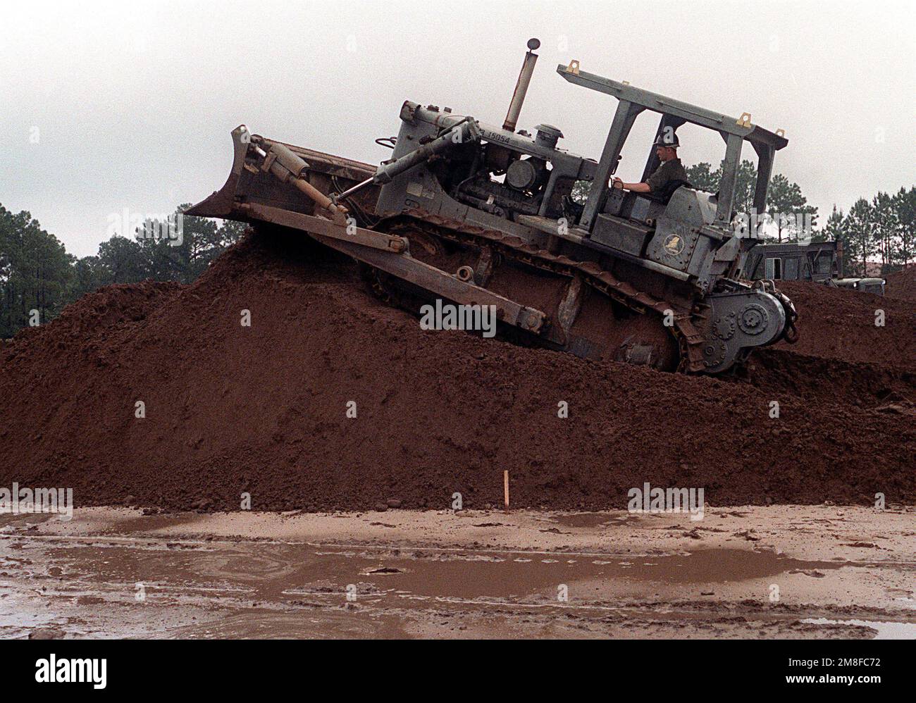 An equipment operator from a Navy Reserve Seabee unit uses a bulldozer ...