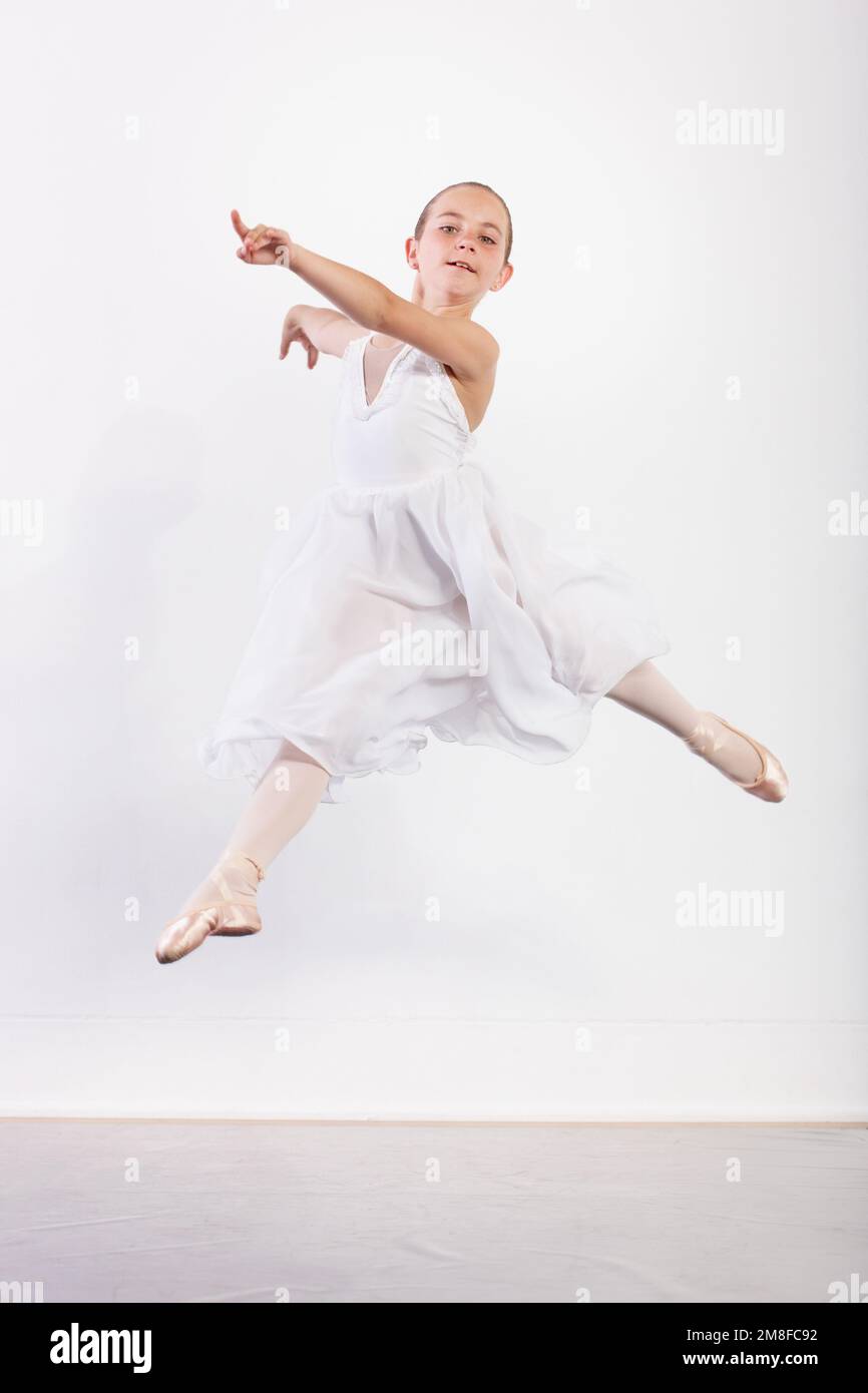 Leaping gracefully. a young ballerina leaping across the floor of a ...