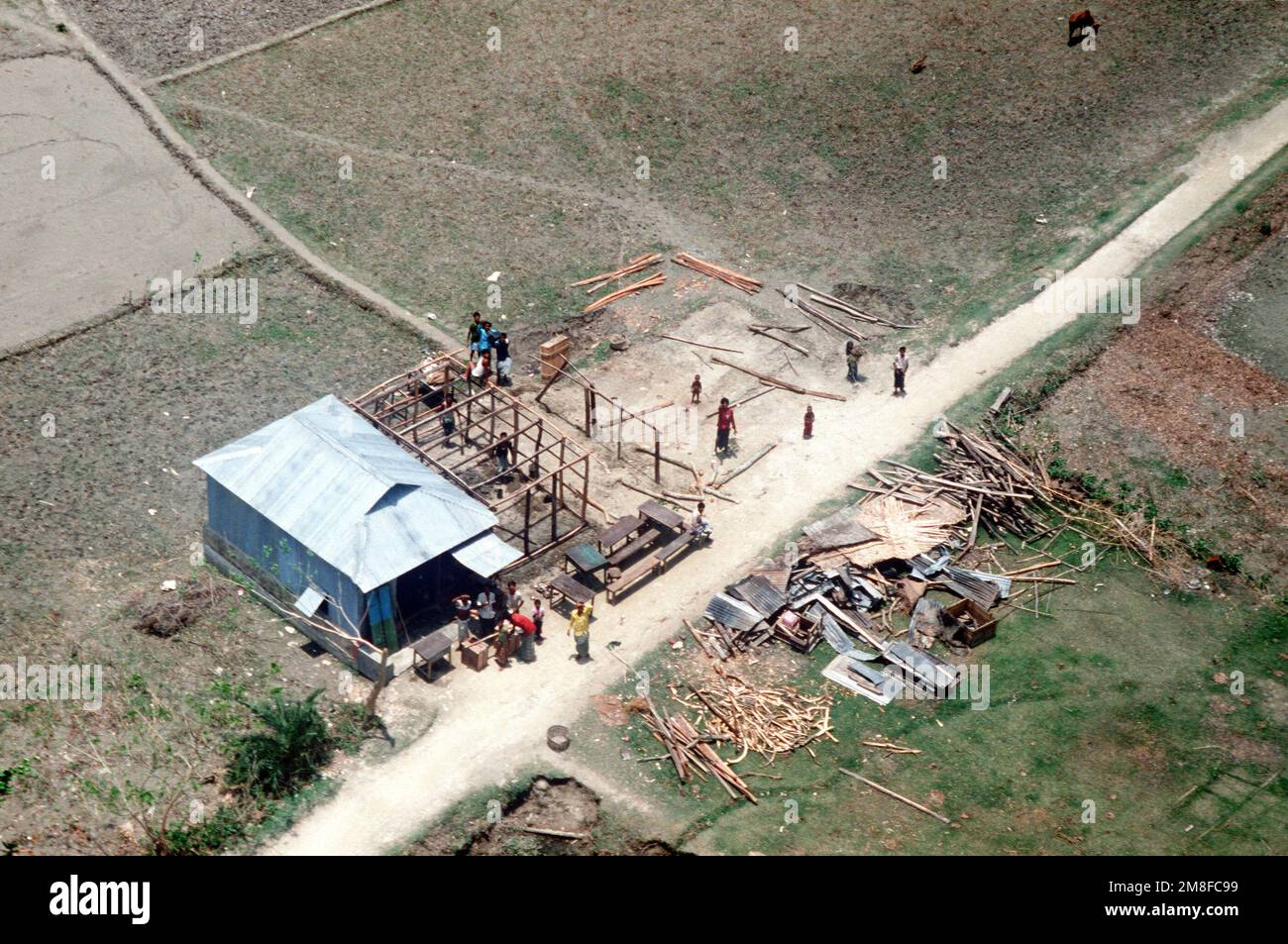 Fragments of buildings are strewn on the ground surrounding a family's ...