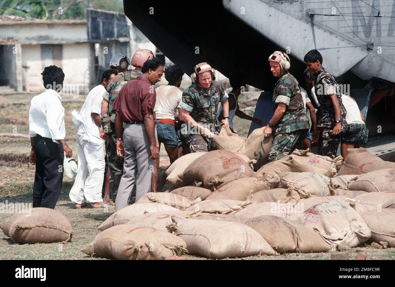 Marines unload sacks of rice and other supplies from a Marine Utility ...