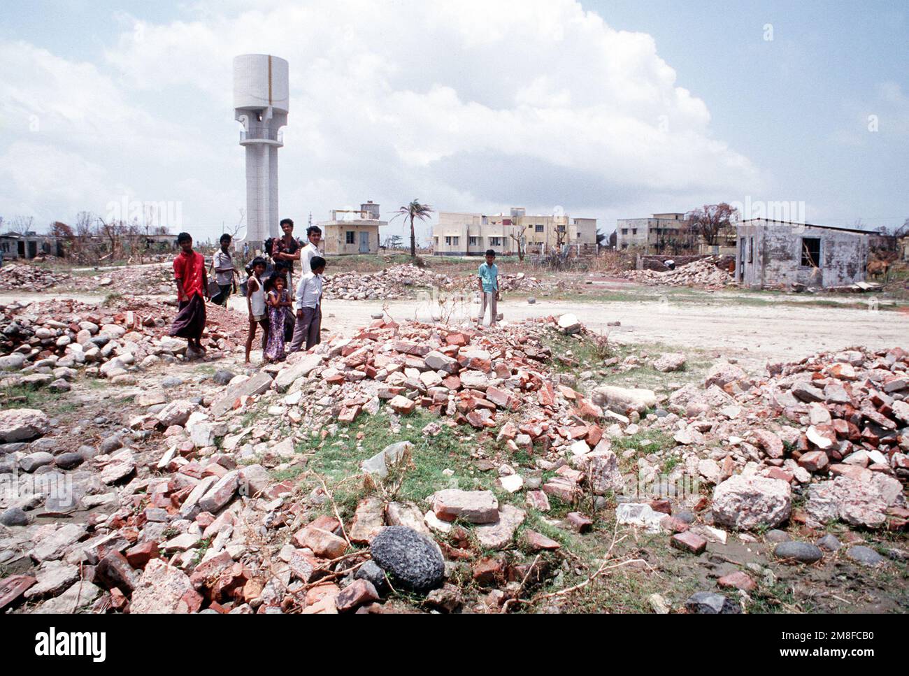 Local residents stand amidst the rubble in the aftermath of a cyclone ...