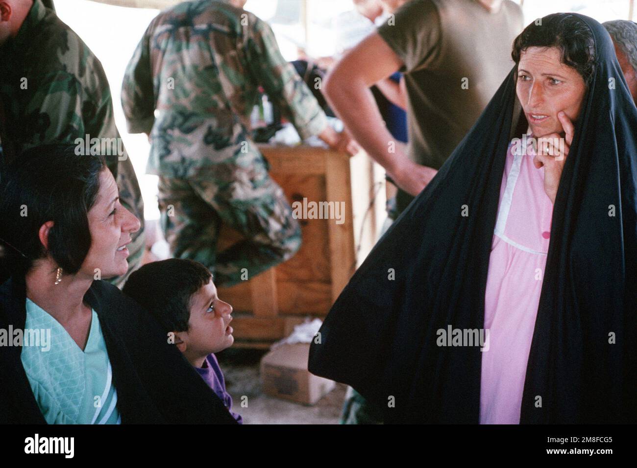 Kurdish refugee women wait for their turn to be checked by Dr. (LT ...