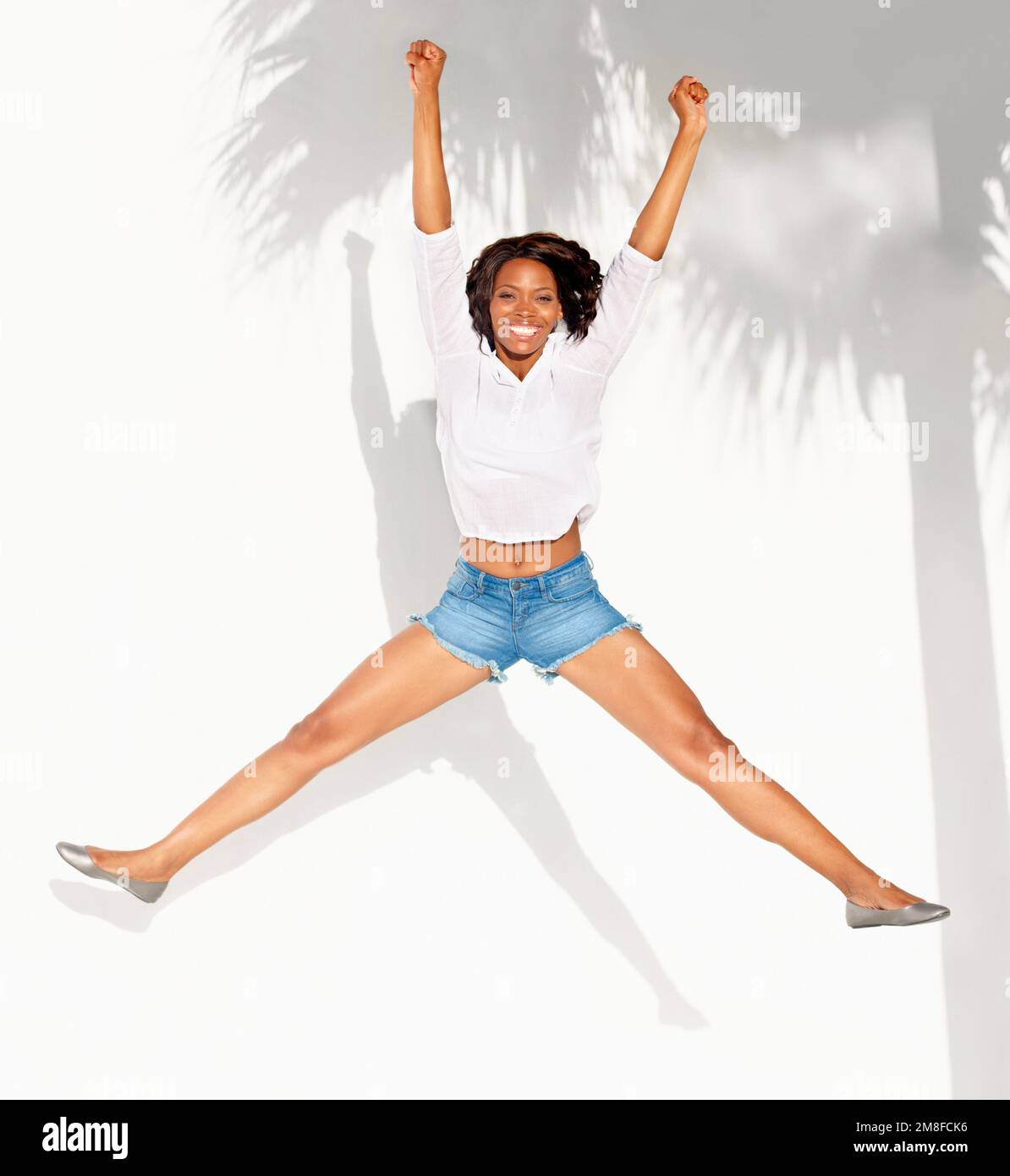 Yes Filled with fun. Young african american woman jumping against a ...