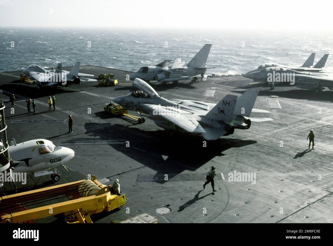 An S-3A Viking aircraft and two F-14A Tomcat aircraft are respotted ...