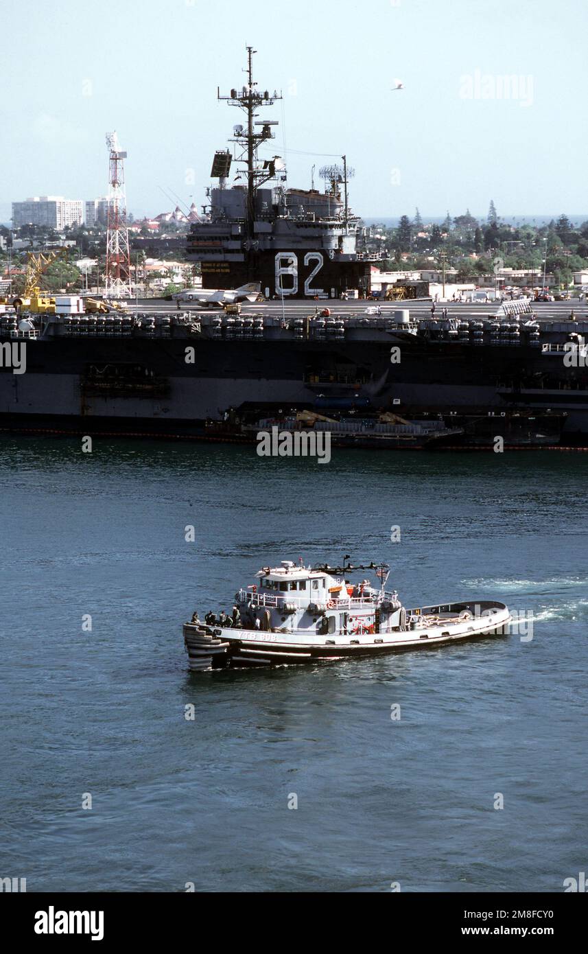 The large harbor tug WENATCHEE (YTB-808) passes near the aircraft ...
