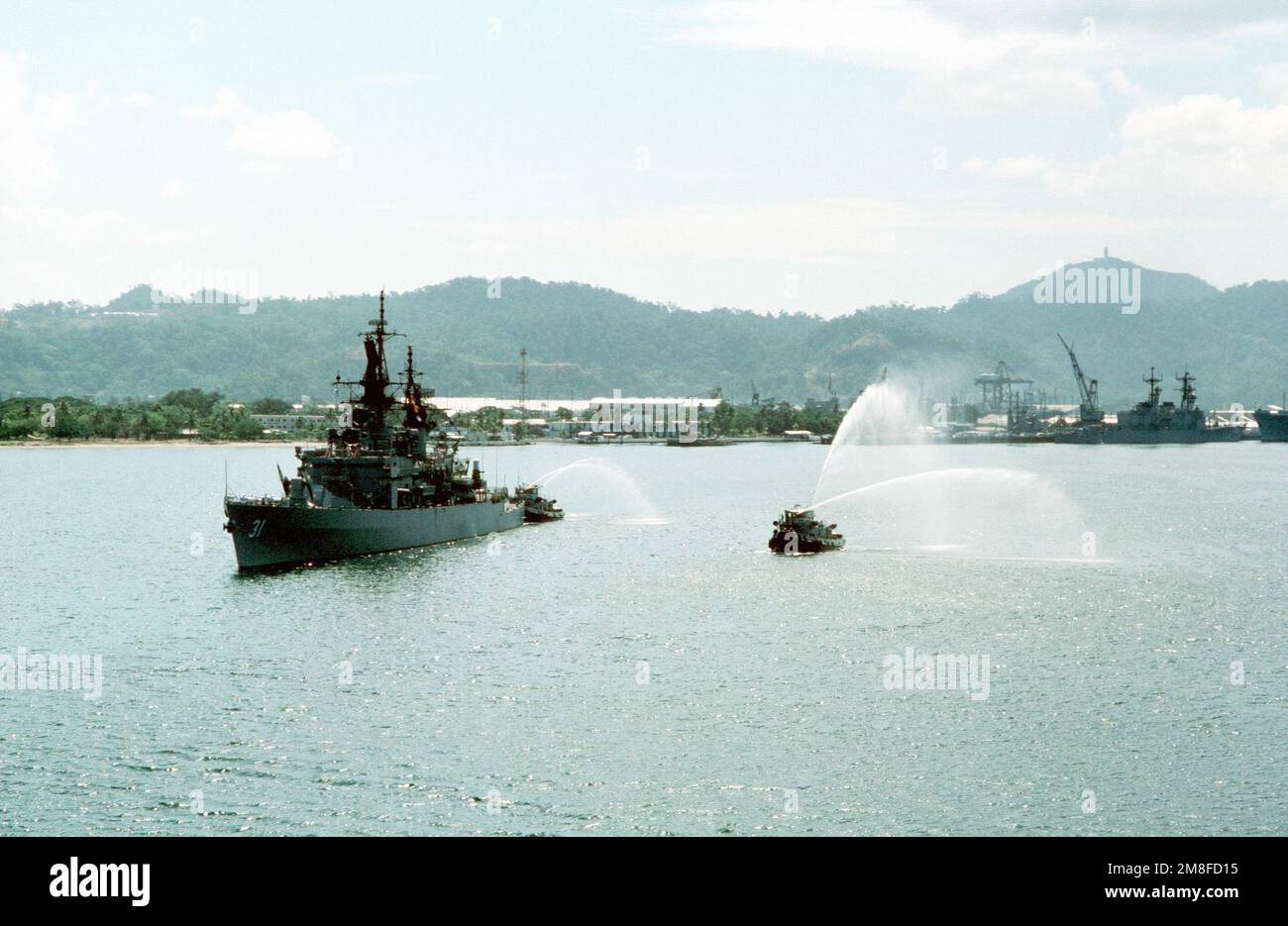 The large harbor tugs WAUWATOSA (YTB-775) and OPELIKA (YTB-798) escort ...