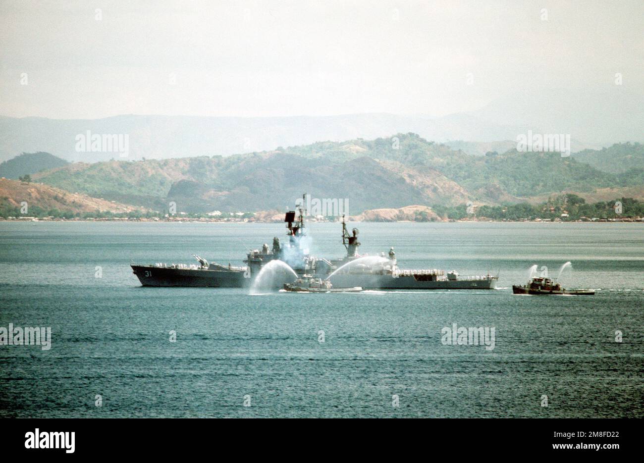 The large harbor tugs WAUWATOSA (YTB-775) and OPELIKA (YTB-798) escort ...