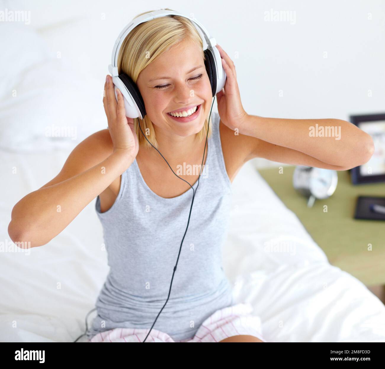 Easy listening. A young woman listening to music on her headphones ...