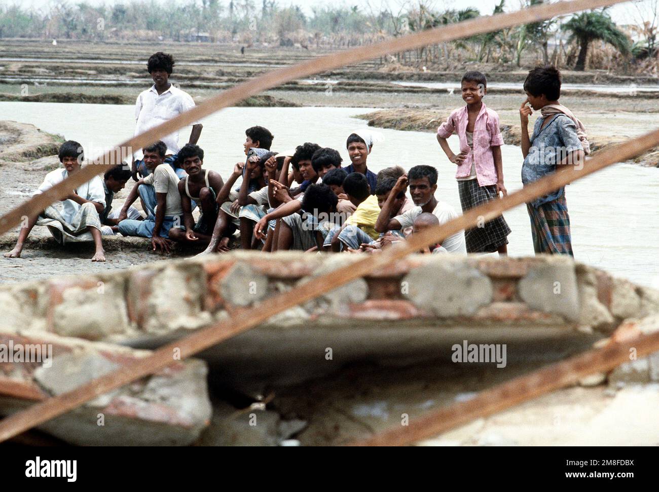 Villagers gather beside the remains of a building destroyed by a ...