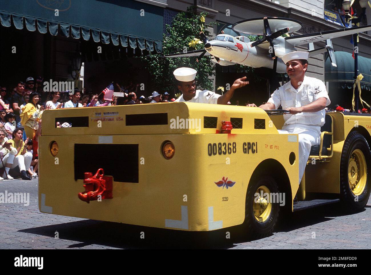A sailor drives an MD-3A tow tractor with a model E-2C Hawkeye aircraft ...