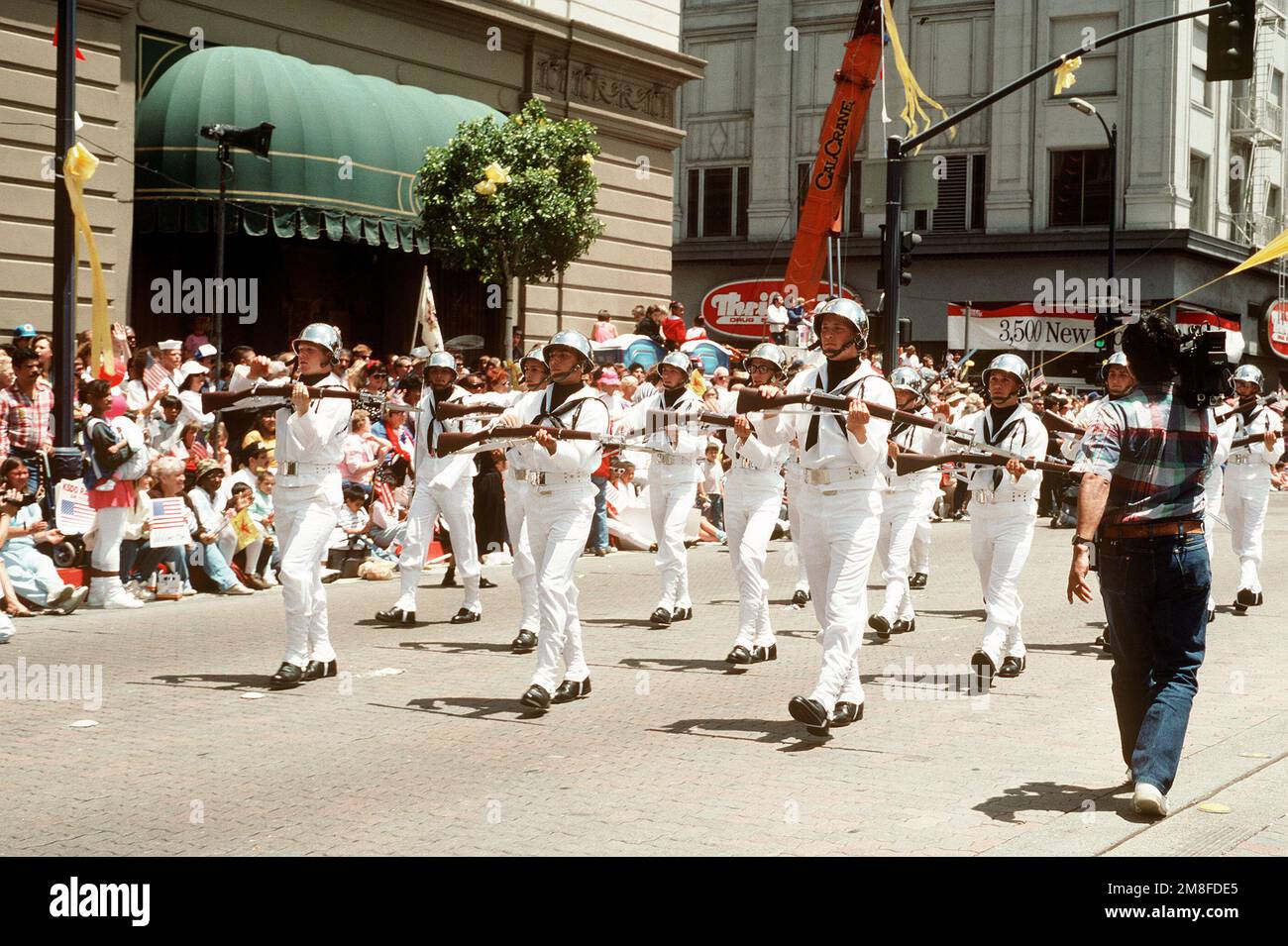 Members of a Navy Junior ROTC drill team march down Broadway Street ...