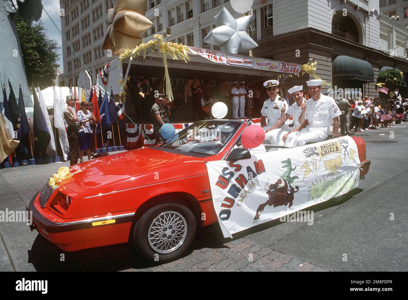 An officer and two enlisted men representing the amphibious cargo ship ...