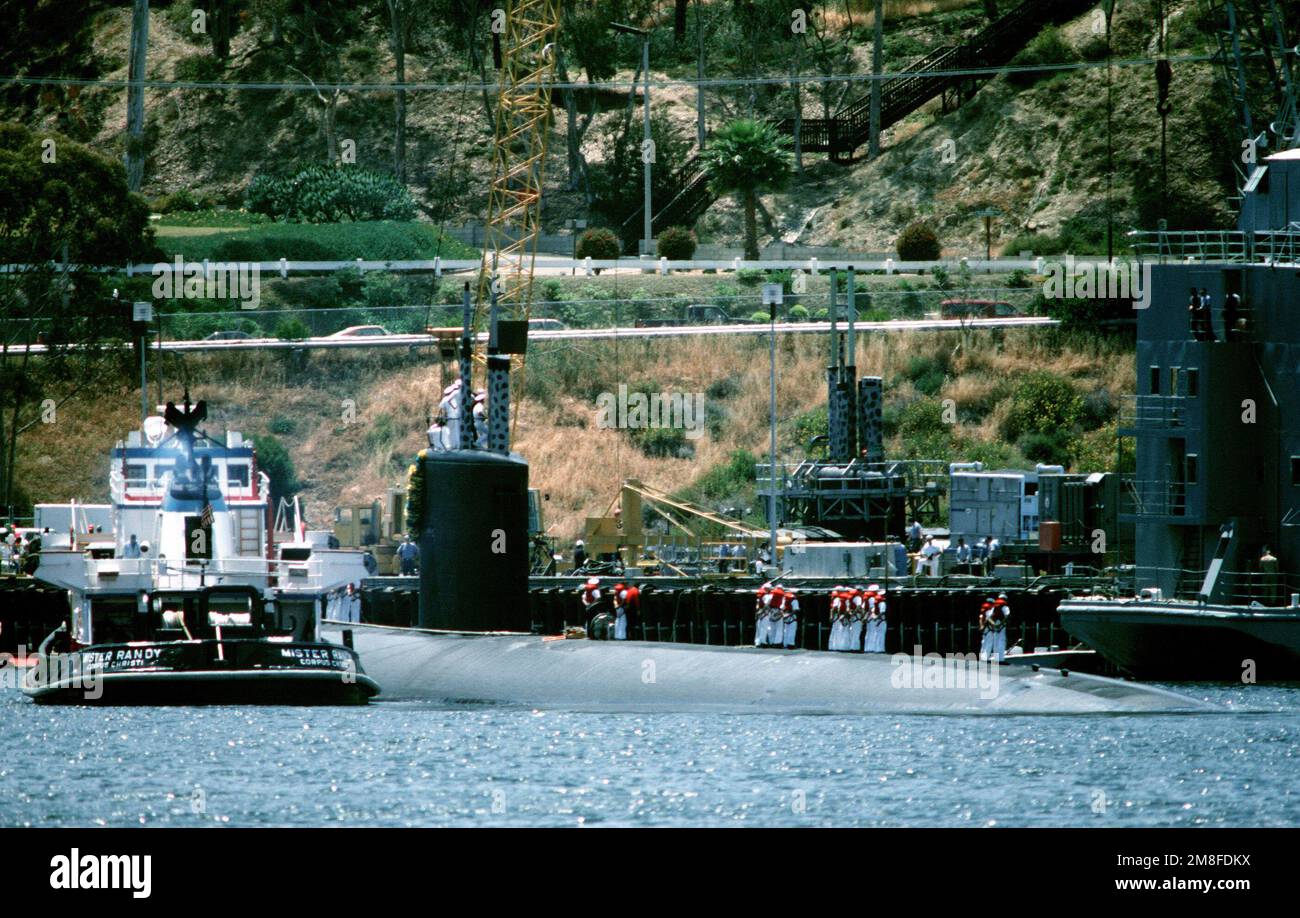 A commercial tug moves the nuclear-cleared attack submarine USS TOPEKA ...