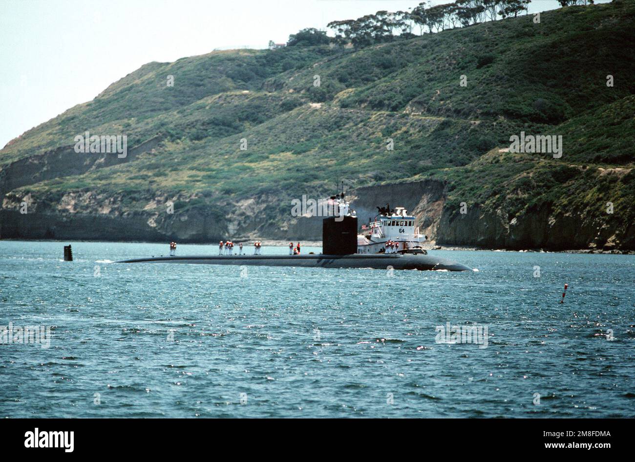 Accompanied by a commercial tug, the nuclear-cleared attack submarine ...