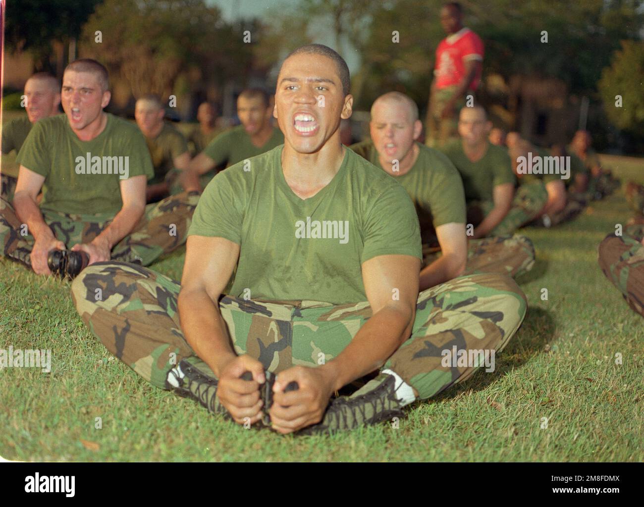 A 2nd Battalion recruit stretches his hamstrings with the rest of his ...