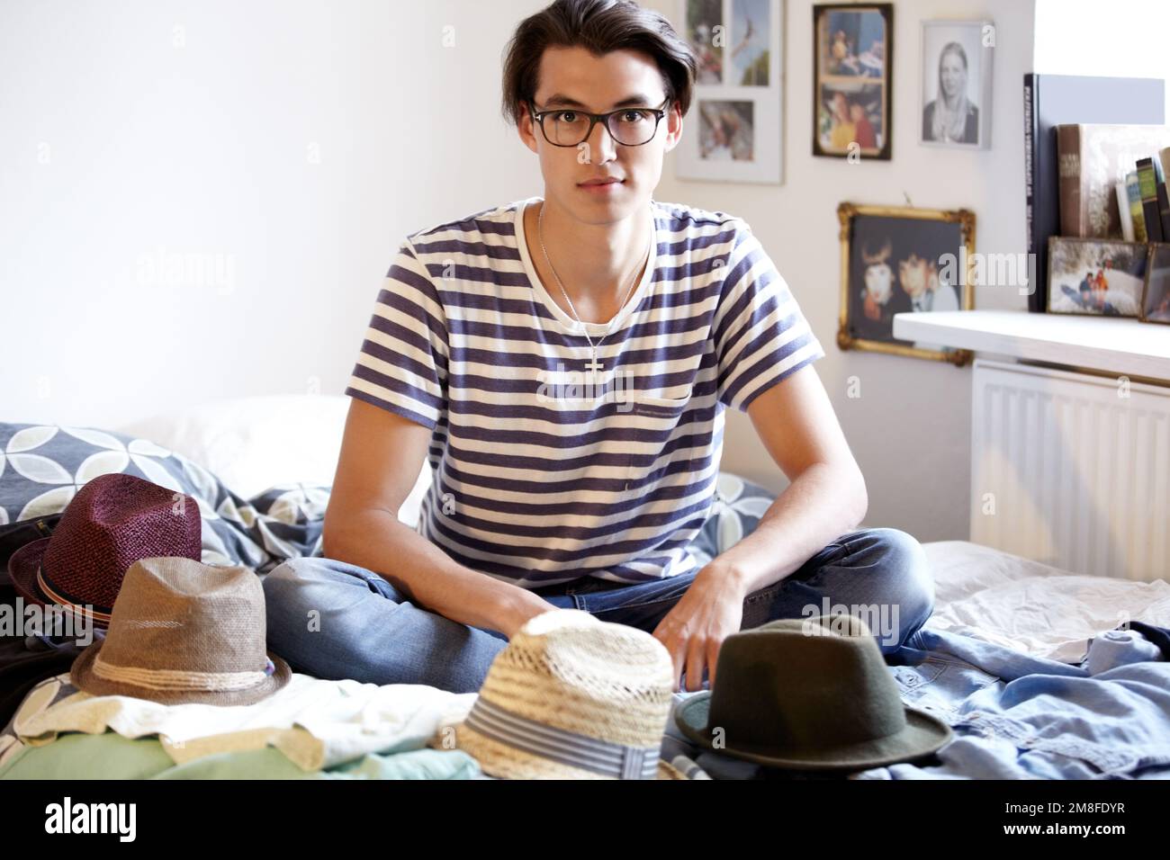 Hes proud of his style. Trendy young guy surrounded by his hat ...
