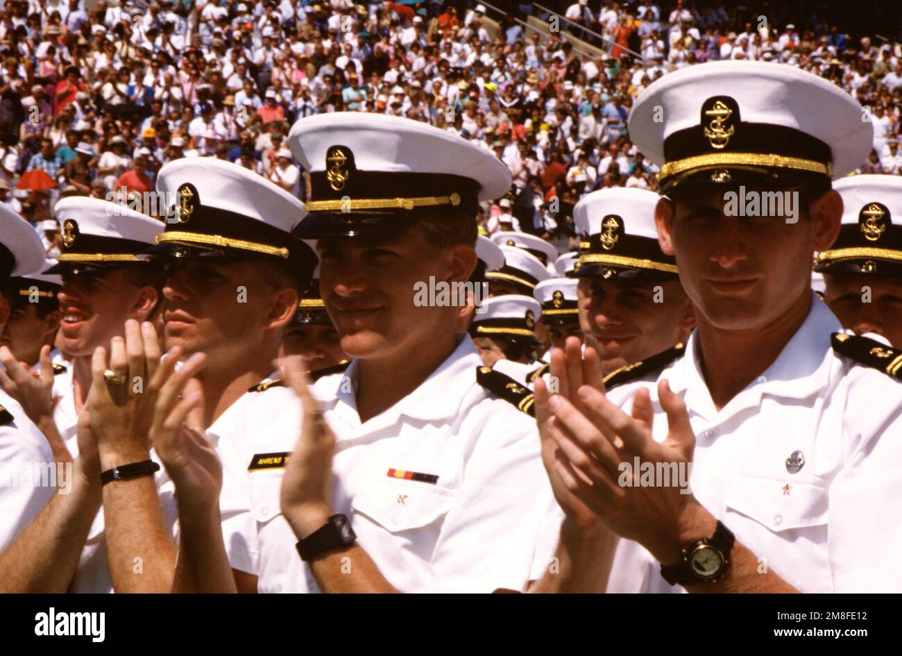 Members of the Naval Academy's Brigade of Midshipmen stand to applaud ...