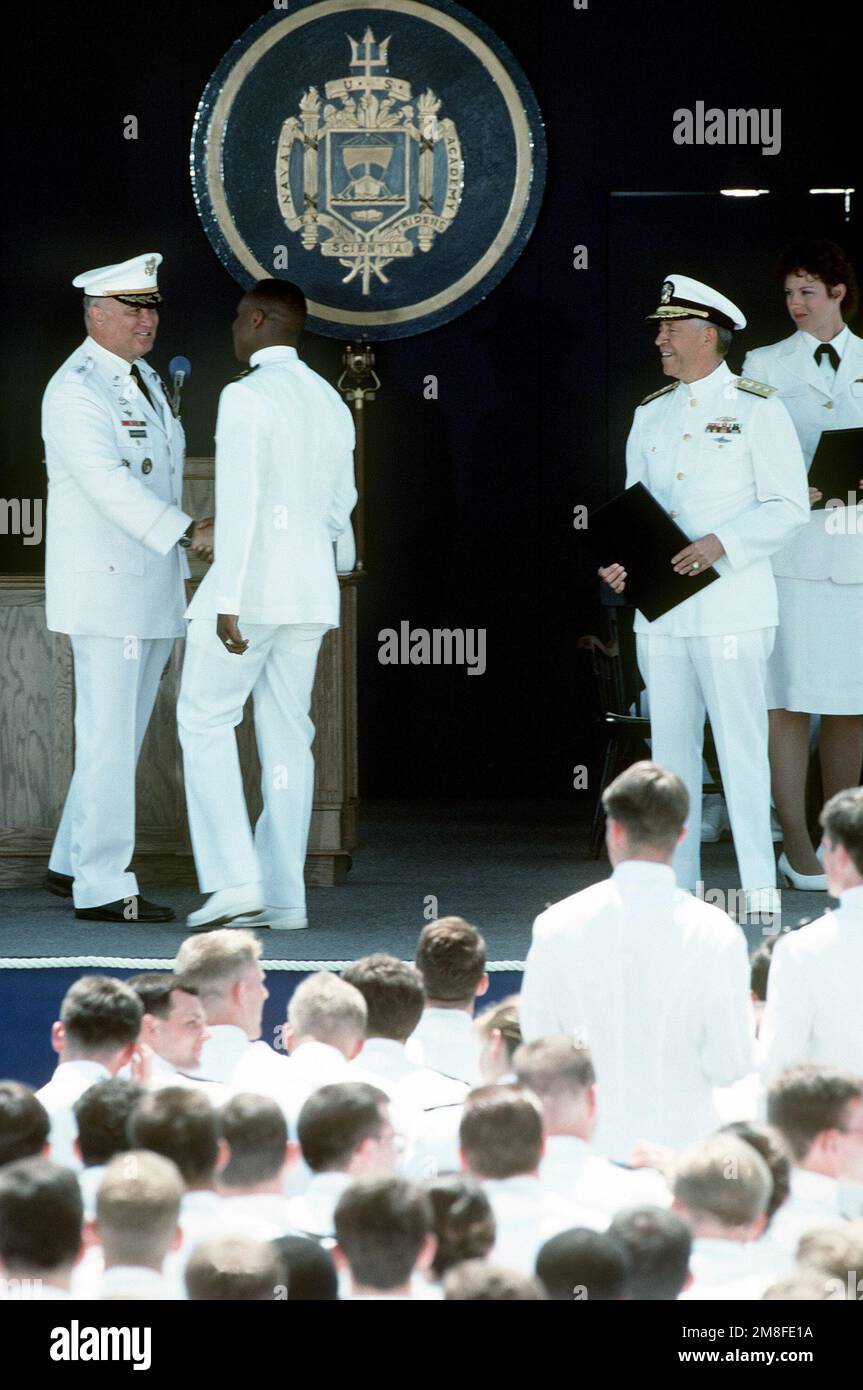 A 1991 graduating midshipman shakes hands with guest speaker Army GEN H ...