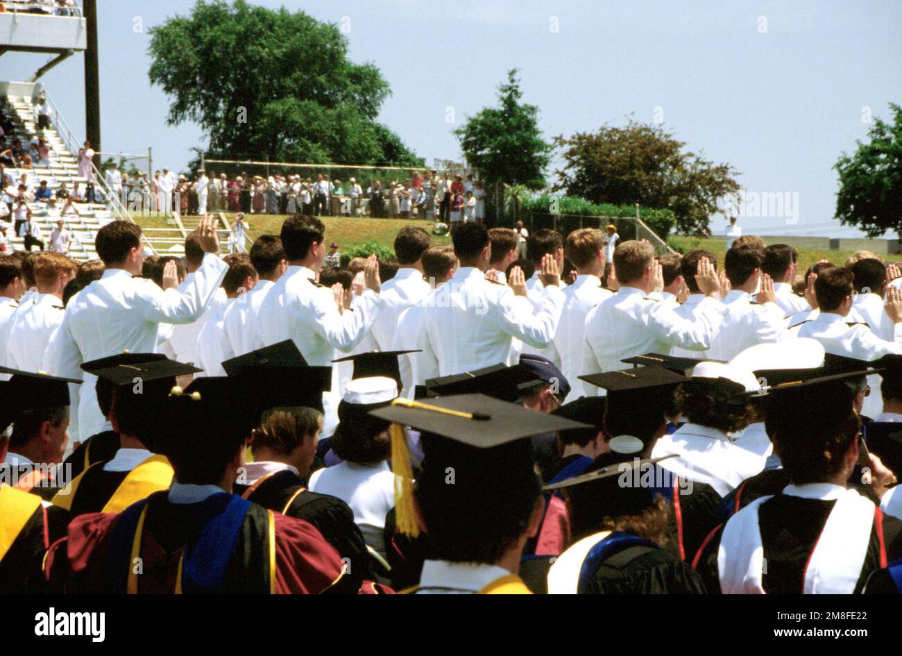 With their right hands raised, members of the Naval Academy's Class of ...