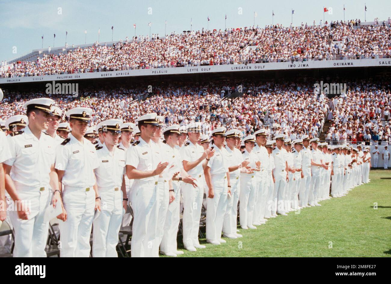 Members of the Naval Academy's Brigade of Midshipmen applaud during the ...