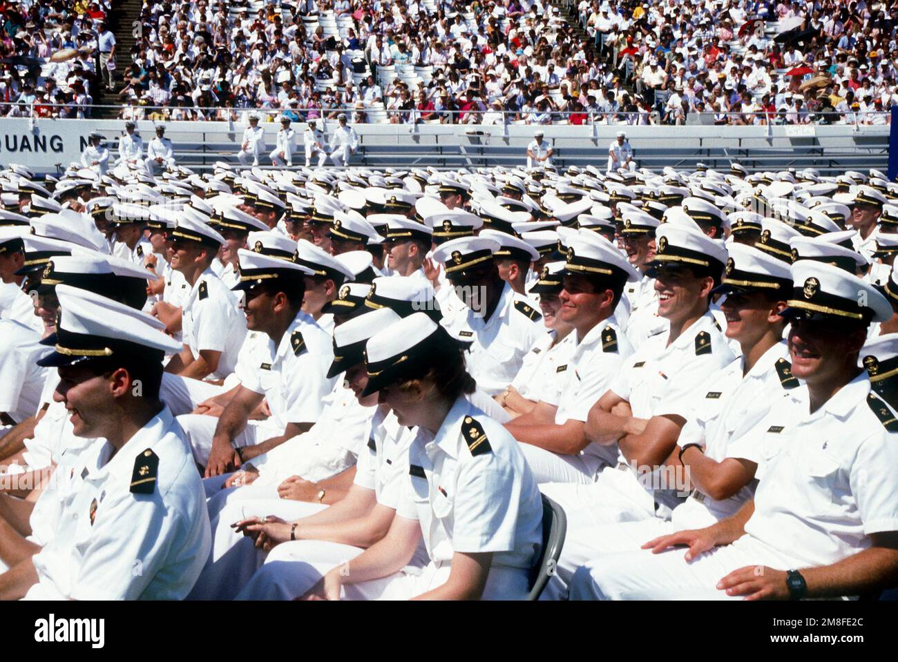 Members of the Naval Academy's Brigade of Midshipmen watch as the ...