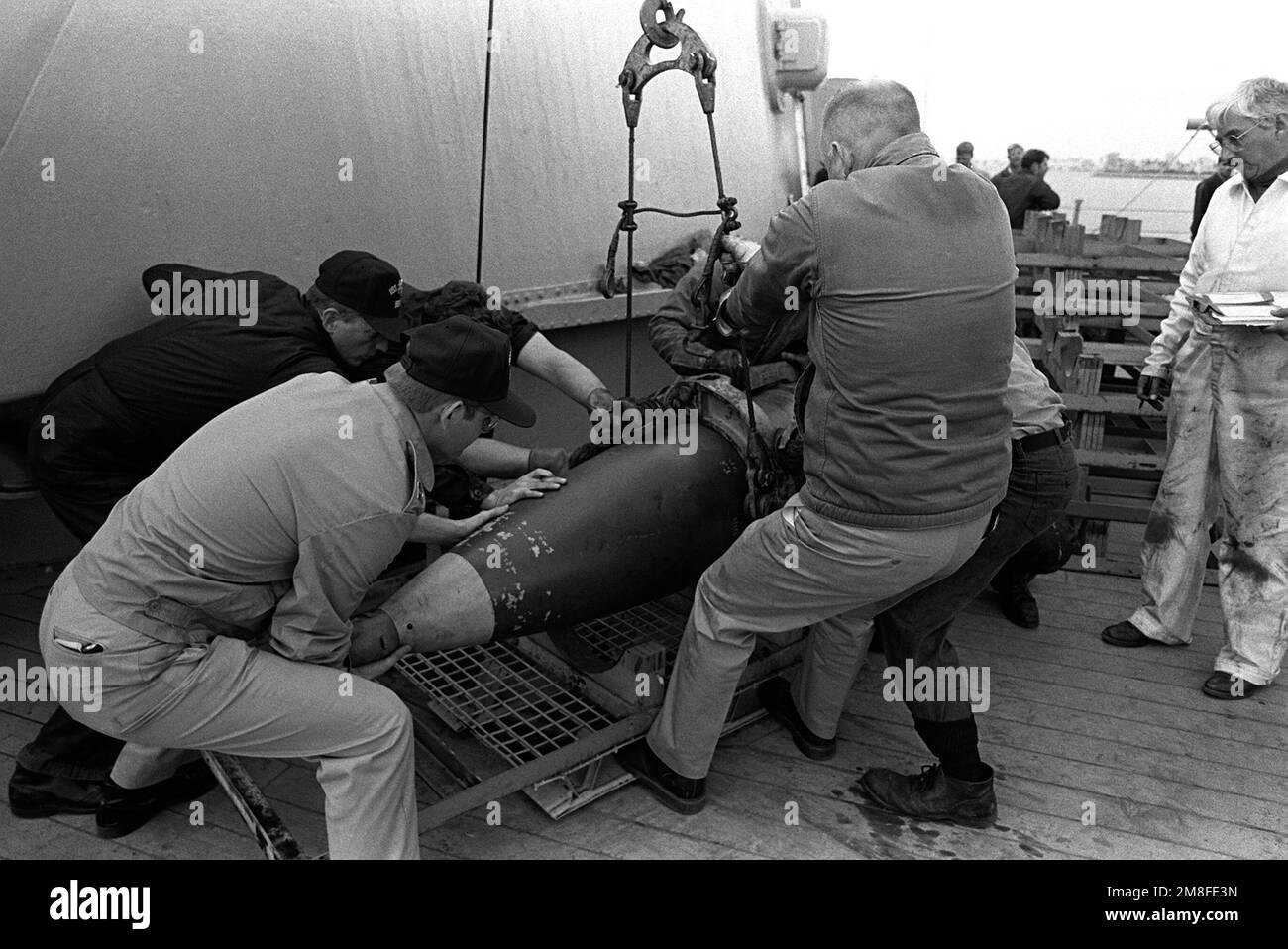 Crewmen position a 16-inch projectile on a pallet on the battleship USS ...