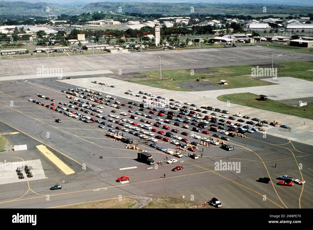 Vehicles line an airfield in preparation for shipment as military and ...
