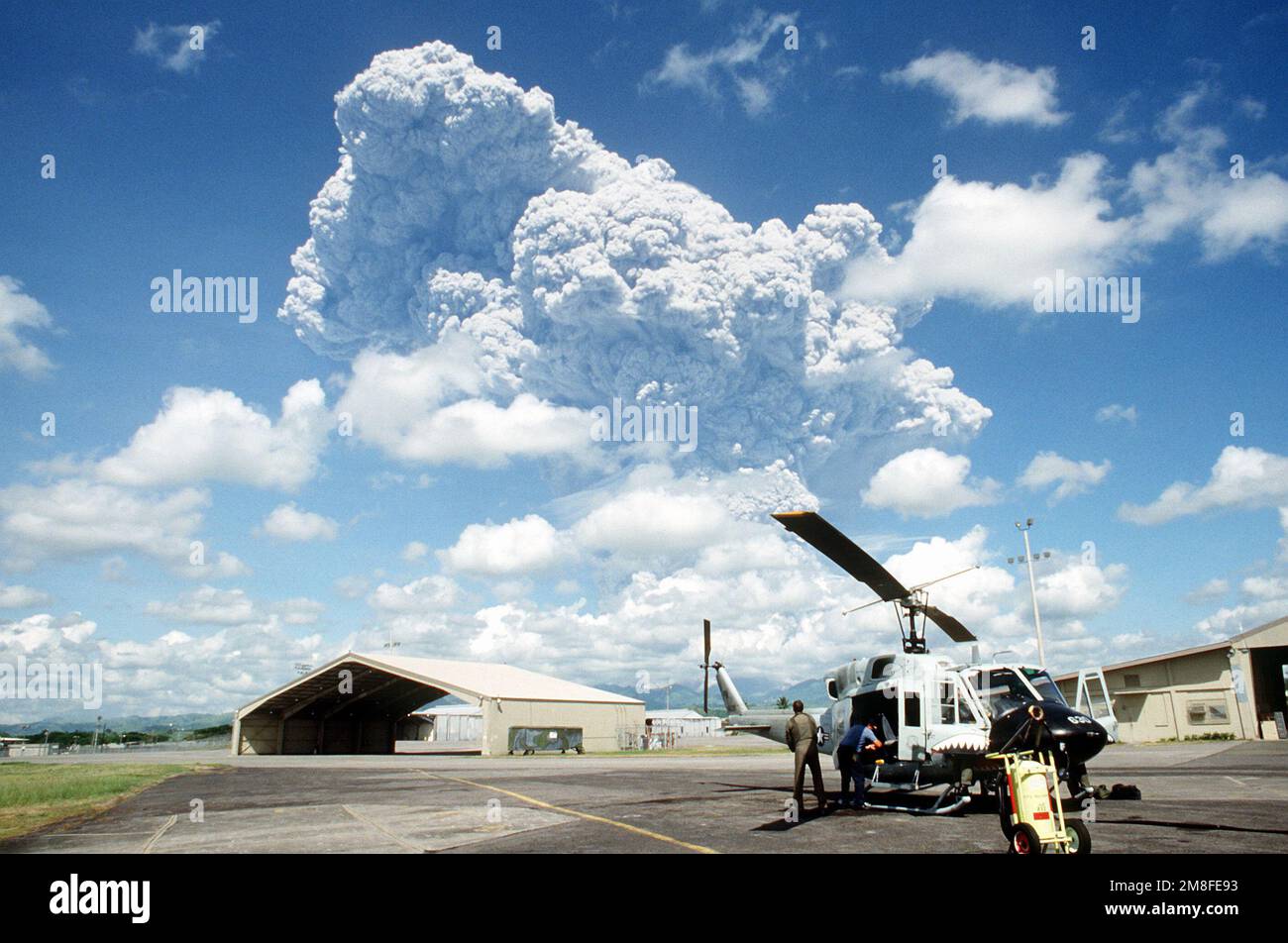 A helicopter crew member stands beside his UH-1N Iroquois helicopter as ...