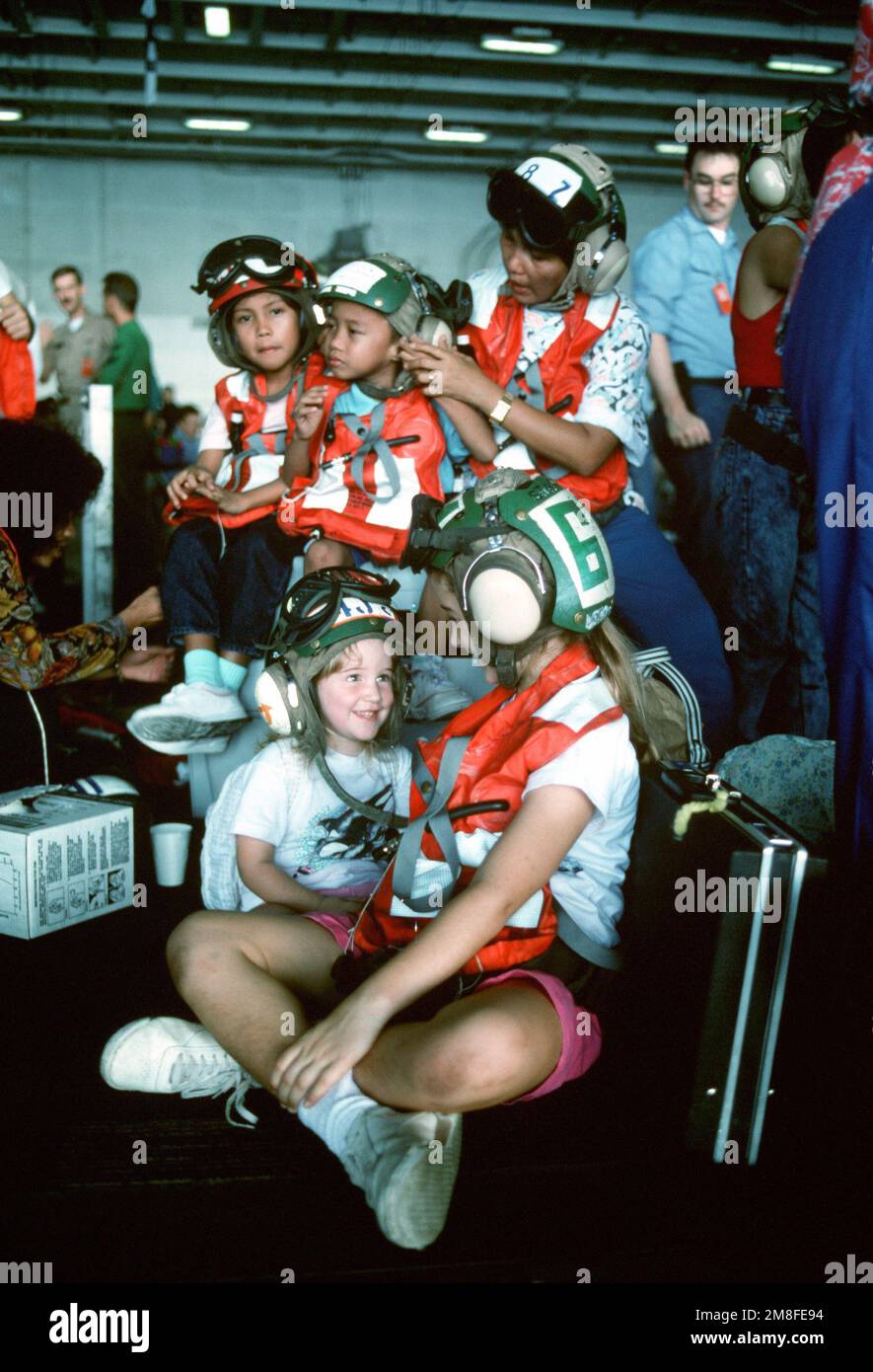 Families wait to board a helicopter aboard the nuclear-powered aircraft ...