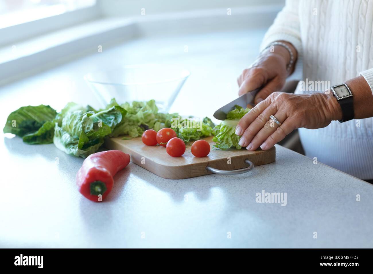 Preparing a healthy meal. View of vegetables being chopped on a cutting ...