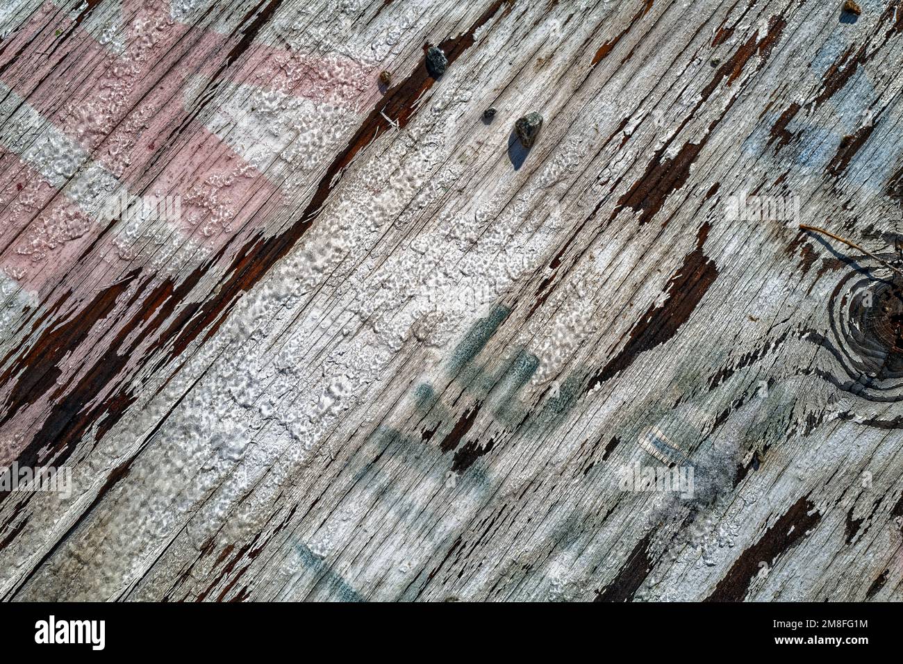 The detail of a rotting wooden board with frost and faded lettering ...