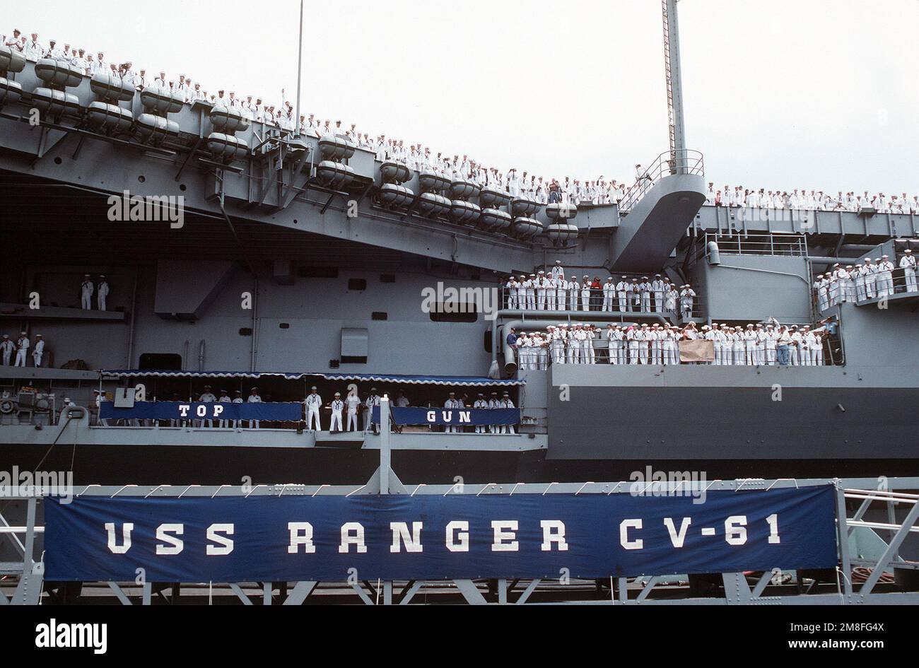 Crew members line the railing aboard the aircraft carrier USS RANGER ...