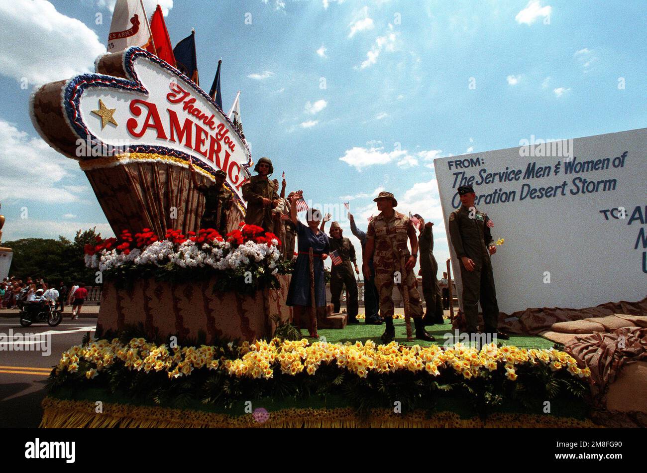 U.S. military personnel stand on a float as they wave to the crowds ...