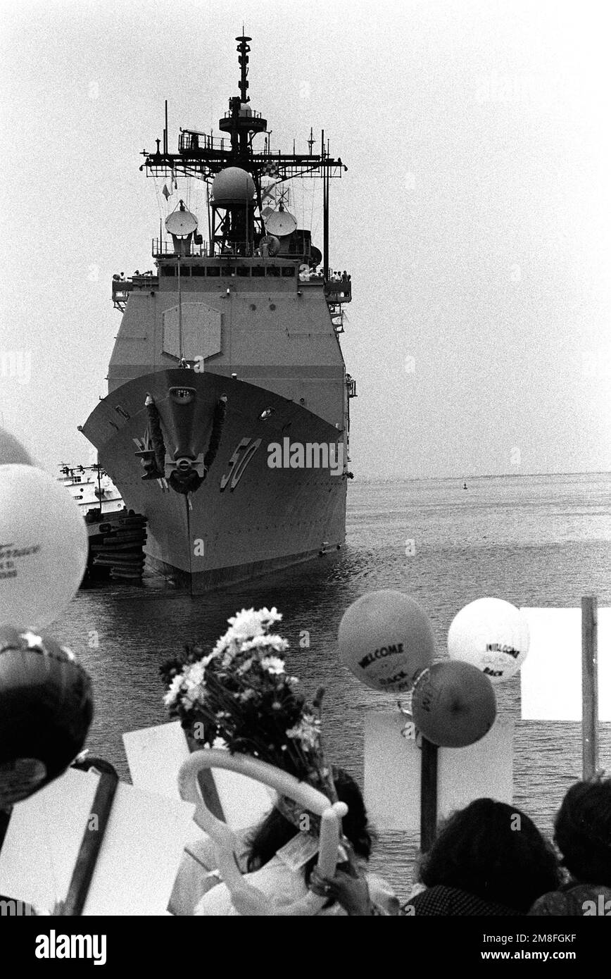Family members and friends wait on the pier as a tug boat helps ...