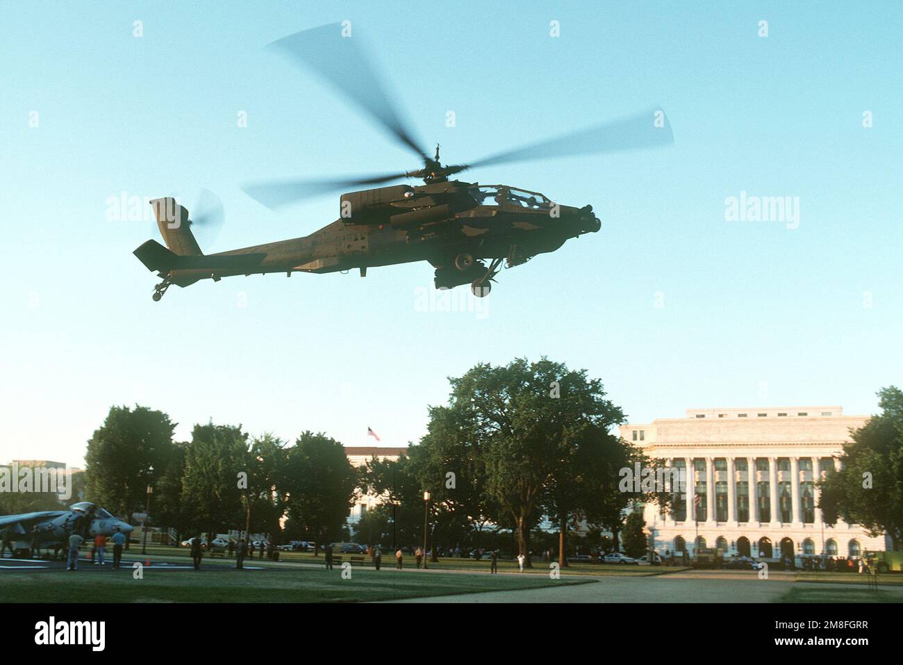 An AH-64 Apache helicopter takes off in front of the Capitol building ...