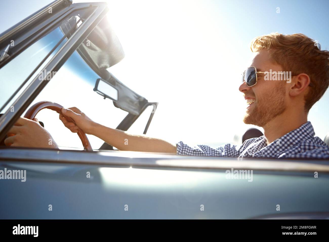 Happy, young man and driving for summer vacation, road trip or journey ...