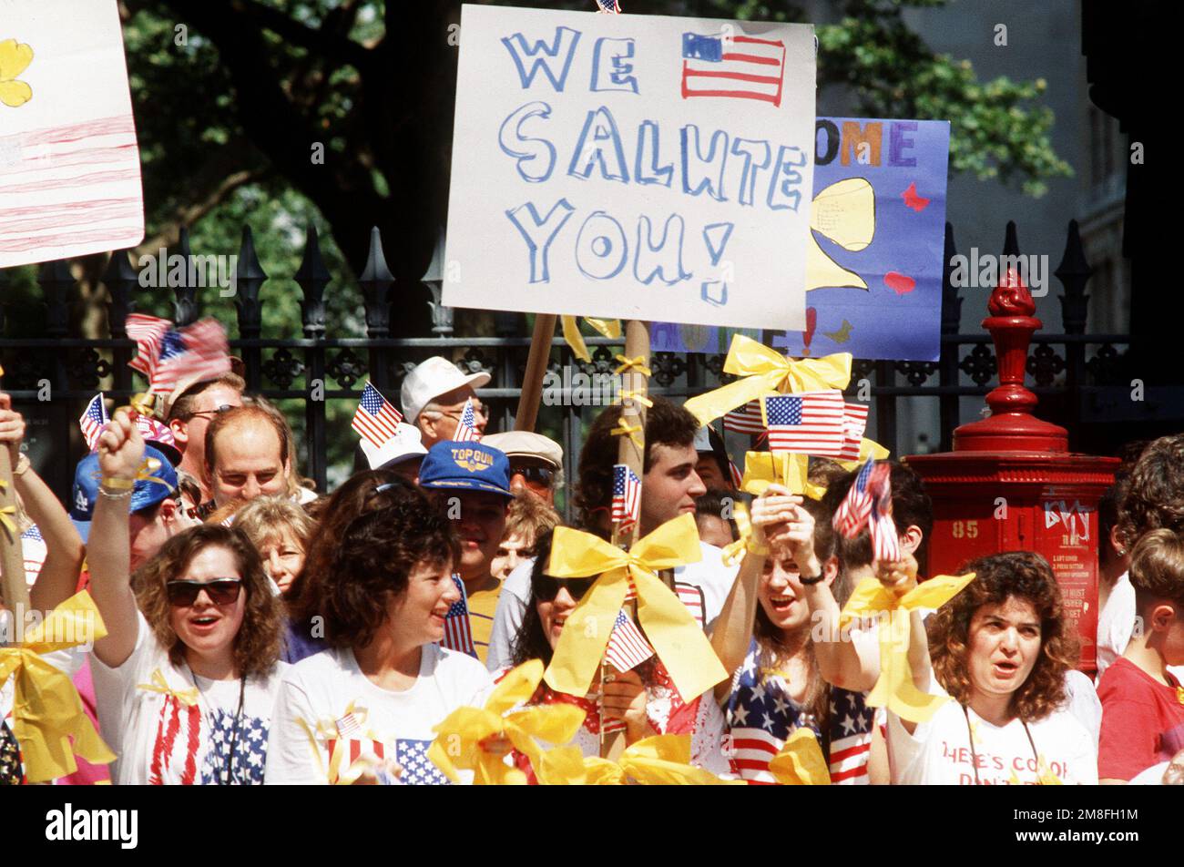 A crowd of excited flag-waving spectators cheer the men and women of ...