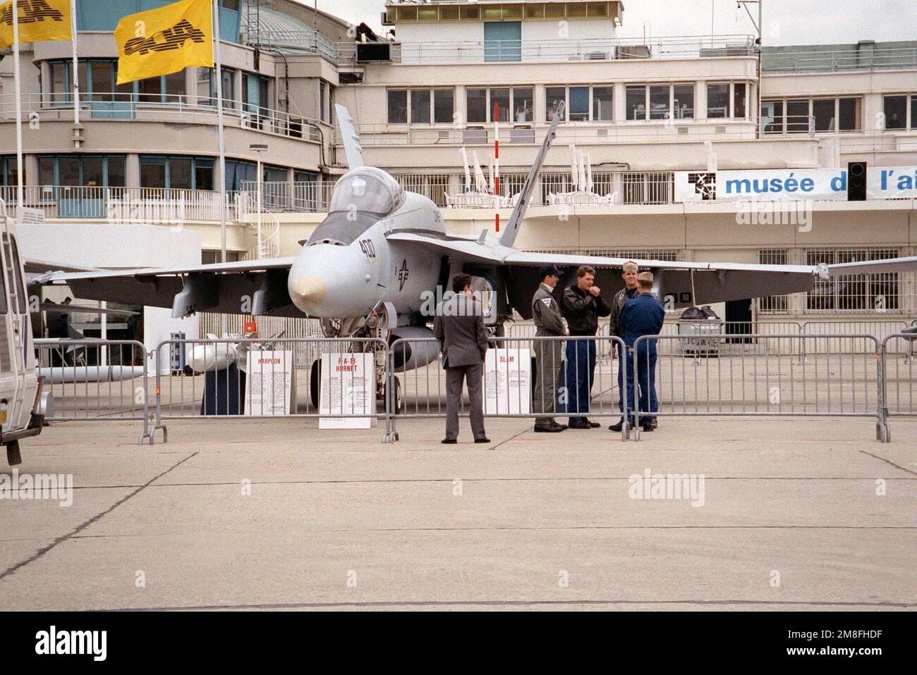 Four pilots stand near a Strike Fighter Squadron 137 (VFA 137) F/A-18A ...