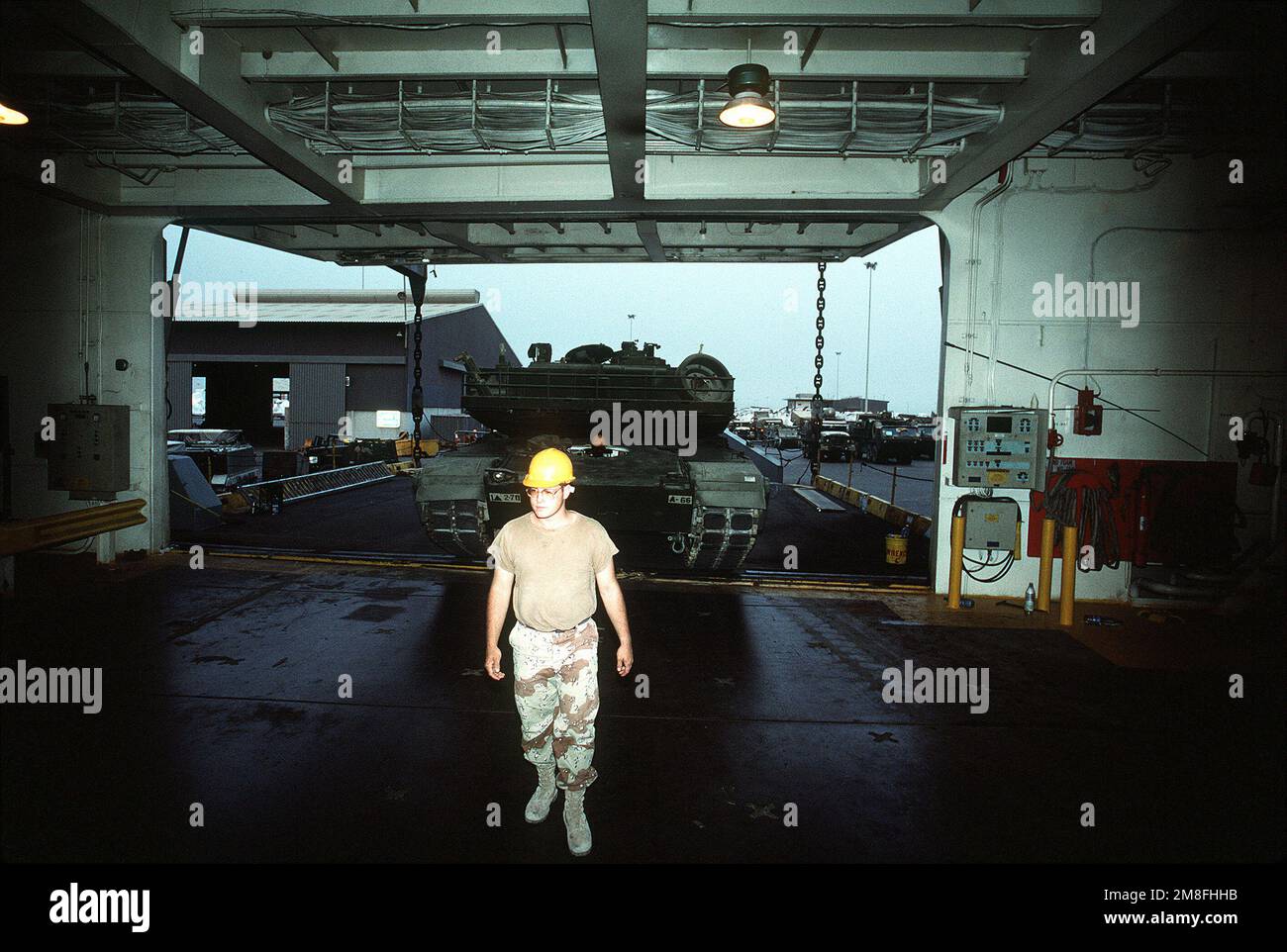 A soldier stands in the cargo hold of a Military Sealift Command ...