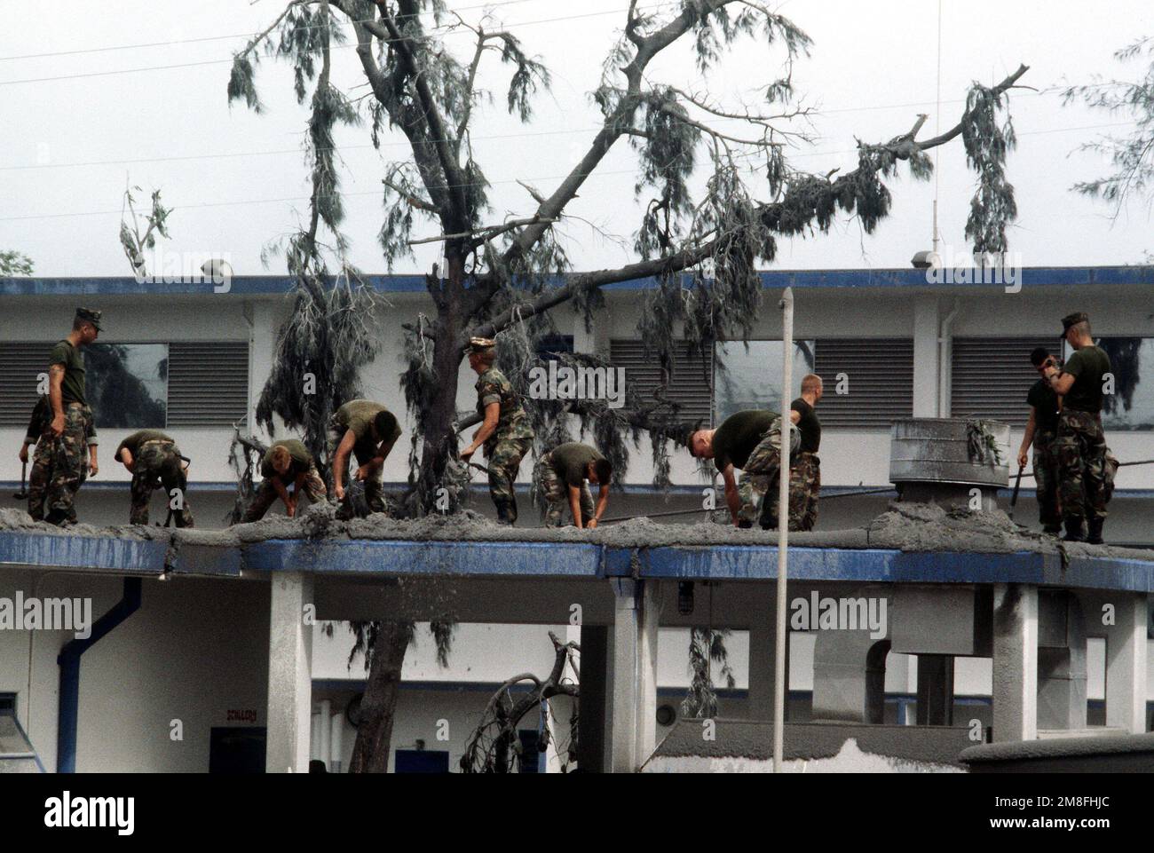 Marines clear off the volcanic ash covering the roof of the Cubi Point ...