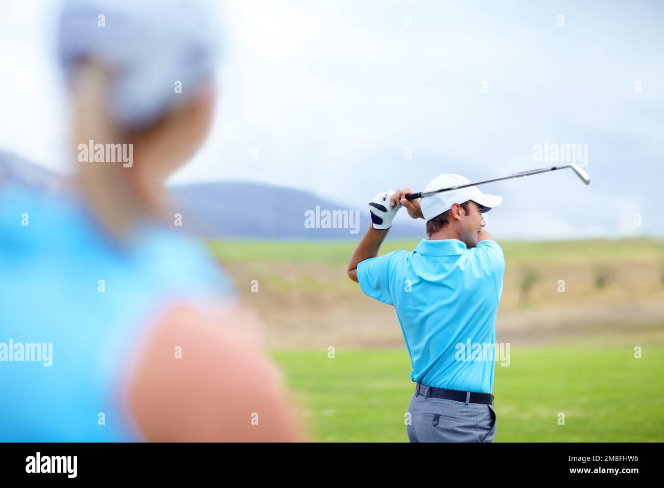 The perfect follow through. Cropped image of a young couple playing a ...