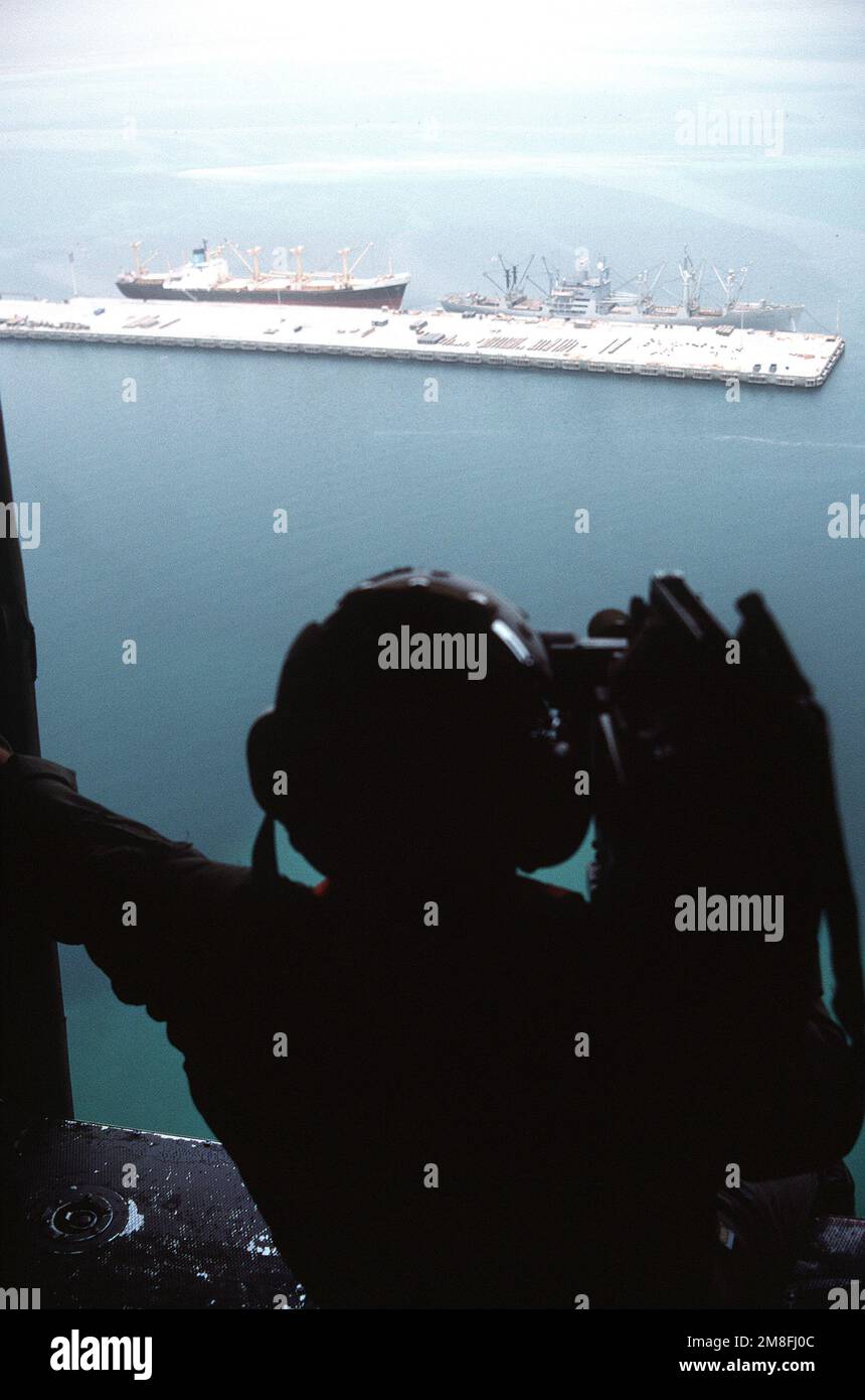 A video cameraman films loading operations from a helicopter as the ...