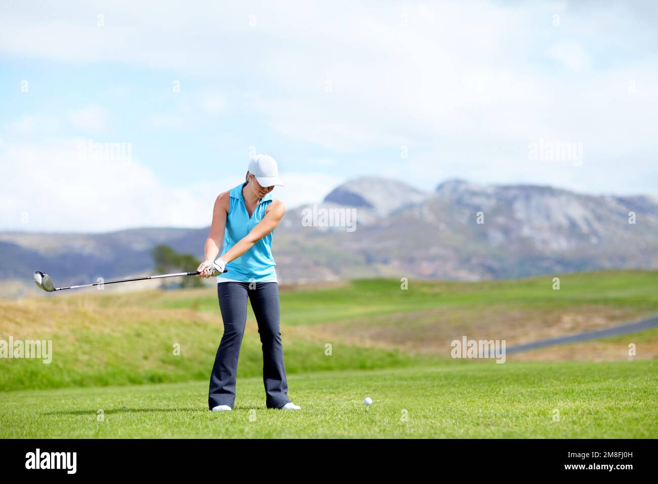 The perfect course to perfect my game. A young female golfer using a ...