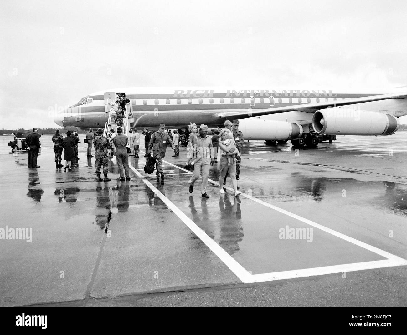 Military and civilian evacuees from the Philippines disembark from a ...