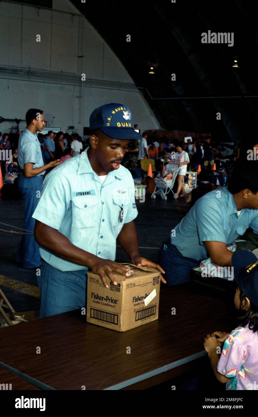 A master-at-arms inspects a family's luggage following their arrival at ...