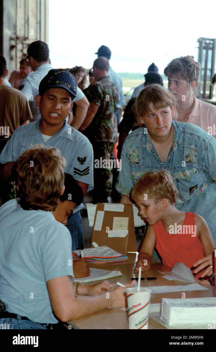 Sailors from U.S. Naval Station, Guam, work at the sign-in desk at a ...