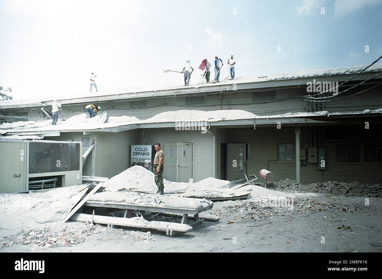 Airmen and Filipino workers clear volcanic ash off the roof of the ...
