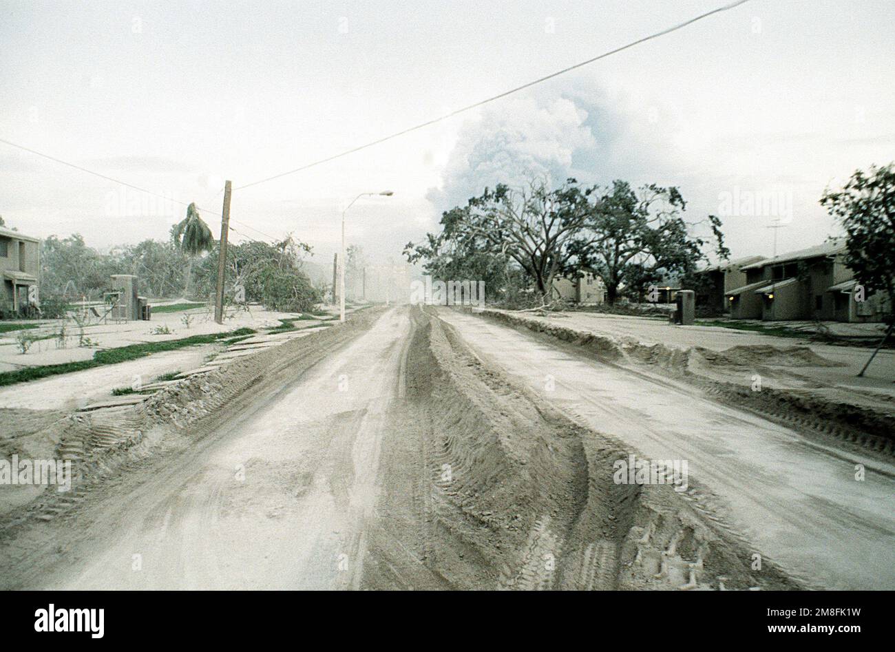 A view of a road partially cleared of its covering of volcanic ash that ...