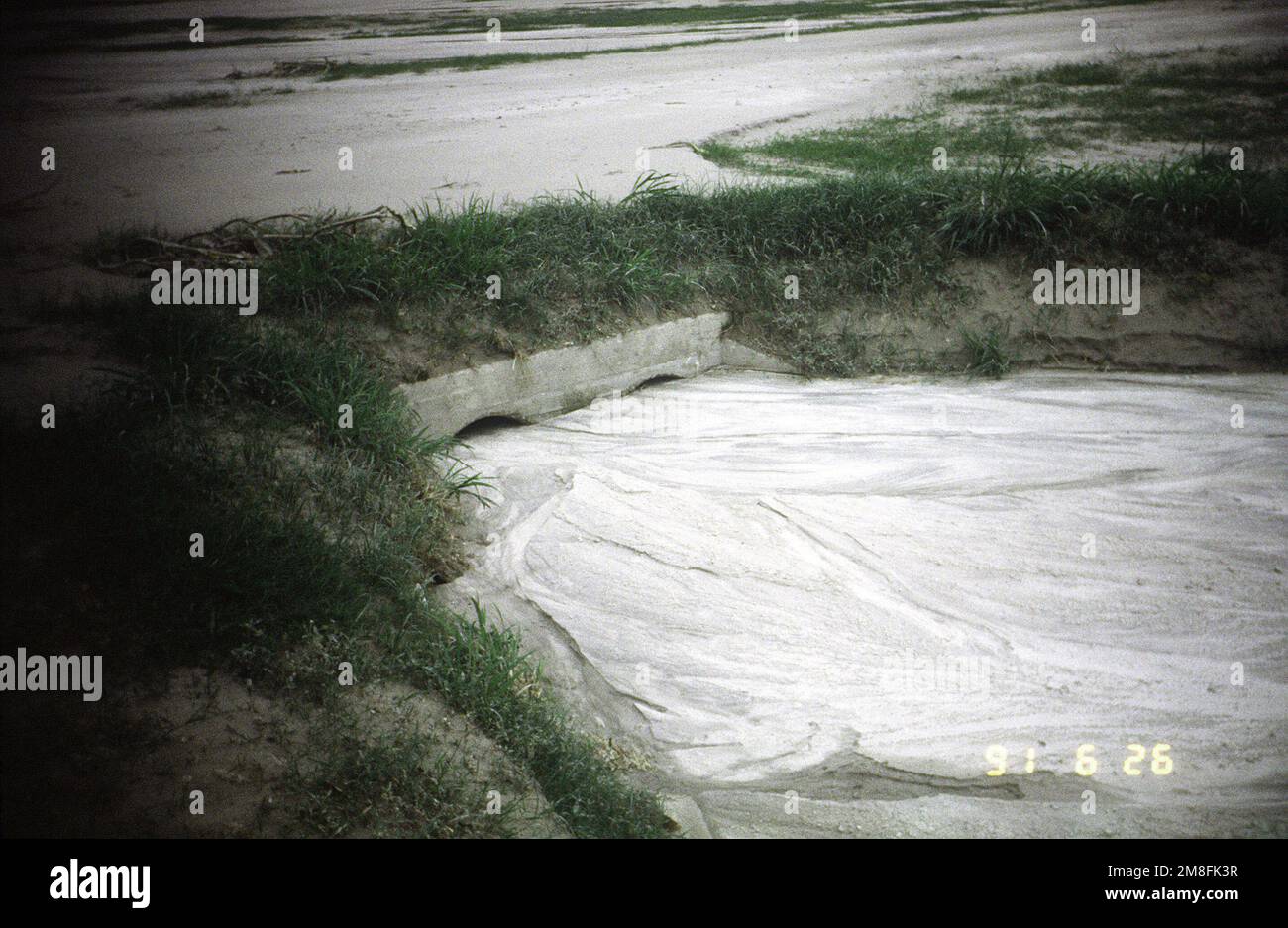 Volcanic ash fills a drainage ditch on the base. The ash fell during ...