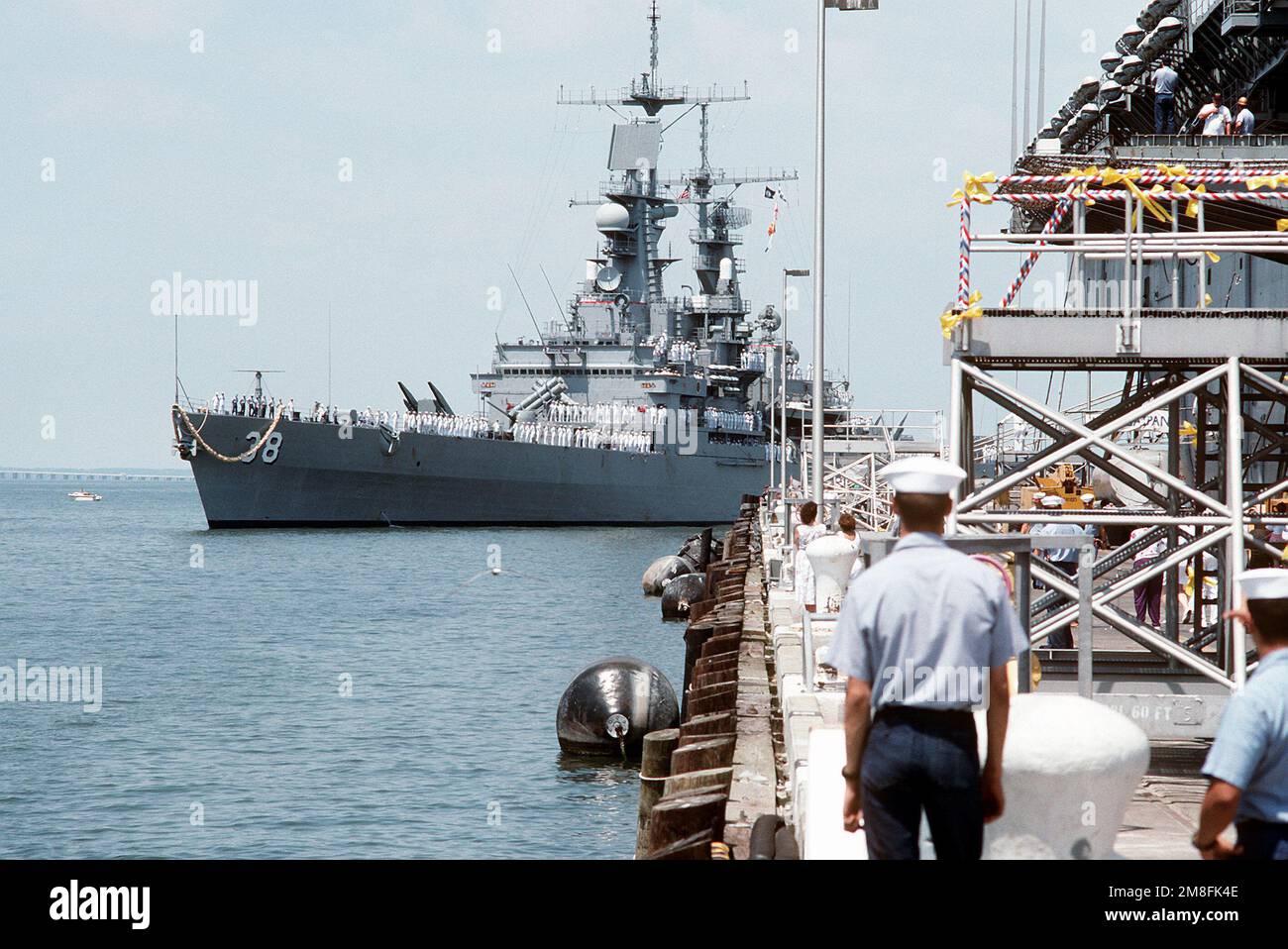 Line handlers stand by on the pier as the nuclear-powered guided ...